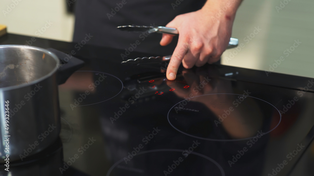 The cook turned on the electric stove. ART. The cook started cooking ...