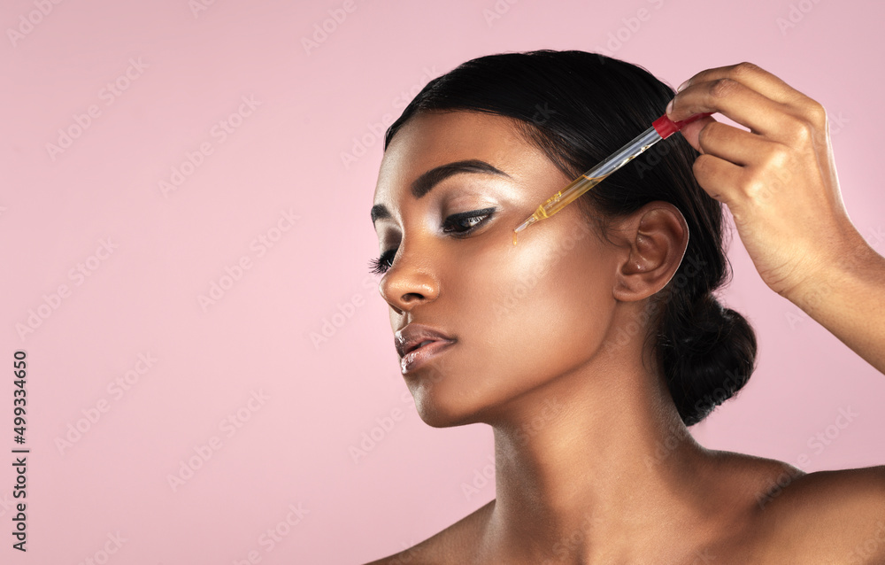Keeping her skin perfect. Studio shot of a beautiful young woman ...