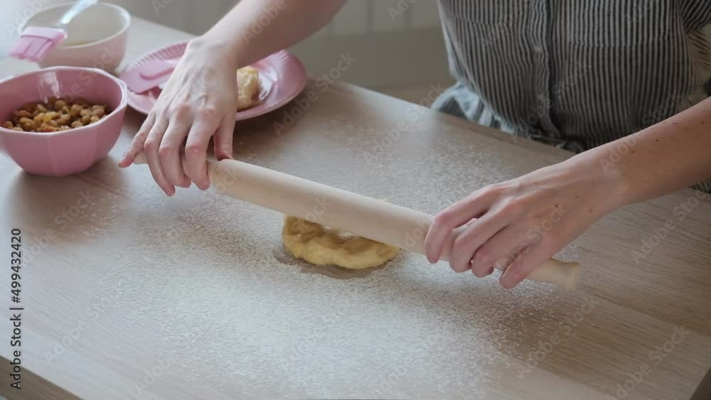 Female baker hands rolling dough with rolling pin. The process of ...