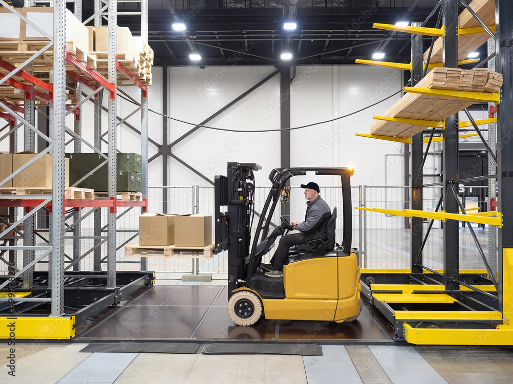 Forklift with drivers. Process of loading pallet onto racks. Multi ...