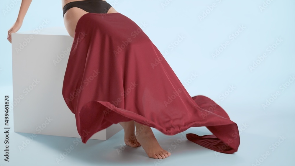 Purple silk cloth sliding down flawless female legs. Slim woman throws ...