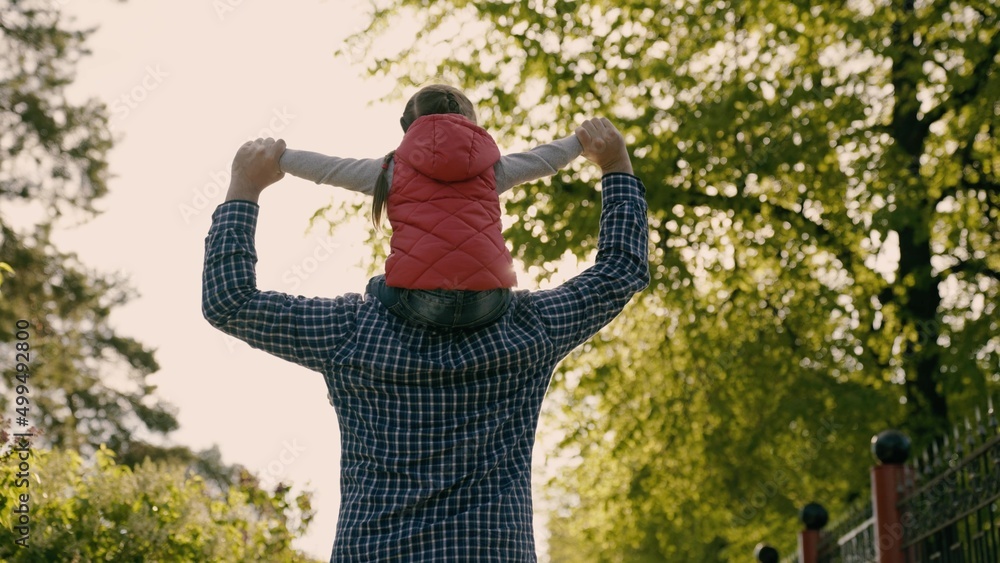 Happy family. Father walks with baby on his shoulders in rays of sunset ...