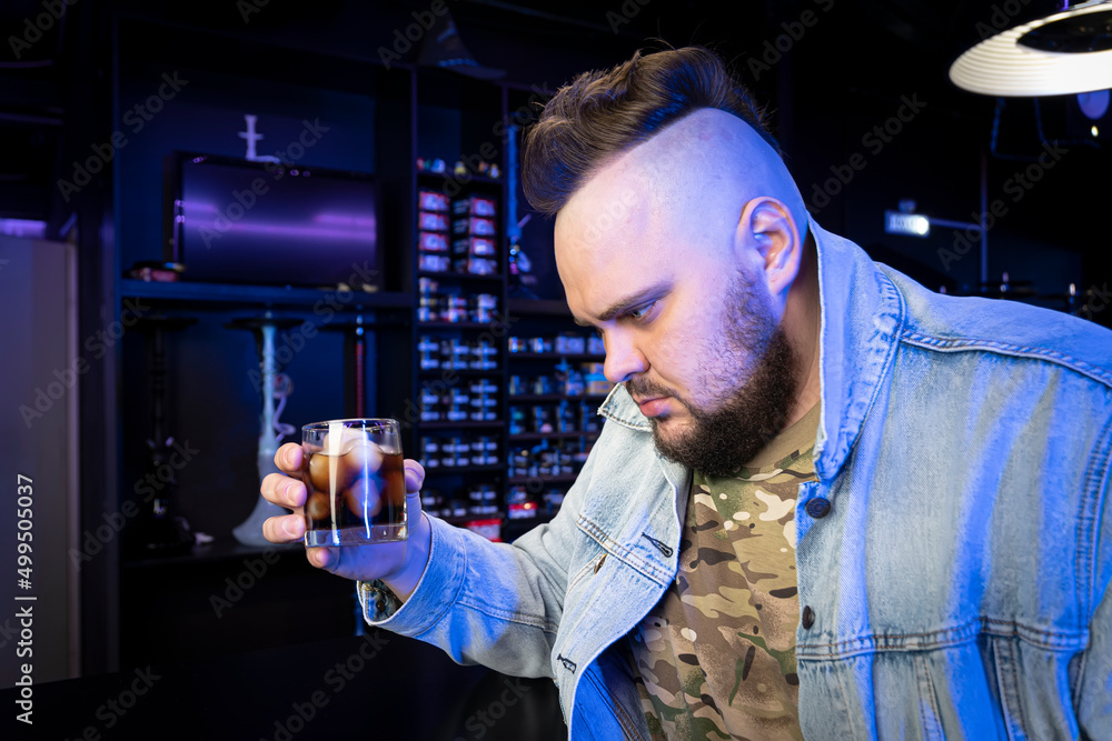 drunk brutal man with an alcoholic cocktail in a glass. The concept of ...