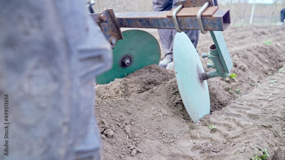Farmer working, ploughing in field with motorized unit motoblock ...