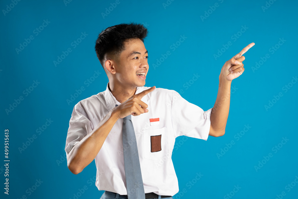 Indonesian high school students pose pointing to the top right with ...