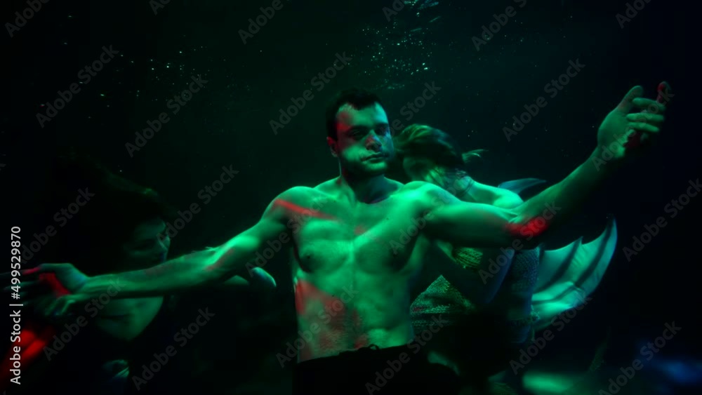 sunken man is drowning in depth and mermaids are swimming around, water ...