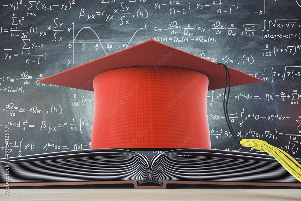 Close up of red graduation cap on open book and chalkboard background ...