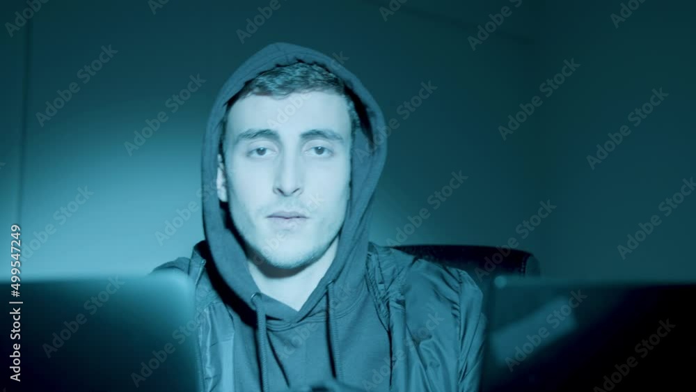 Young Caucasian man sitting at night in front of laptop screen and ...