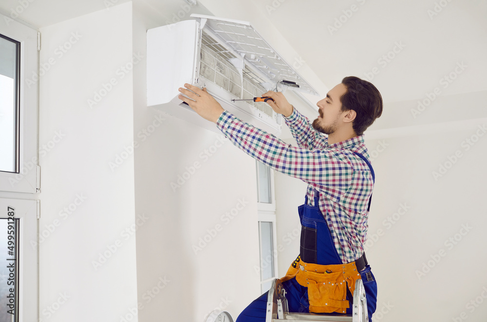 Technician repairing a modern AC system on his typical day at work ...
