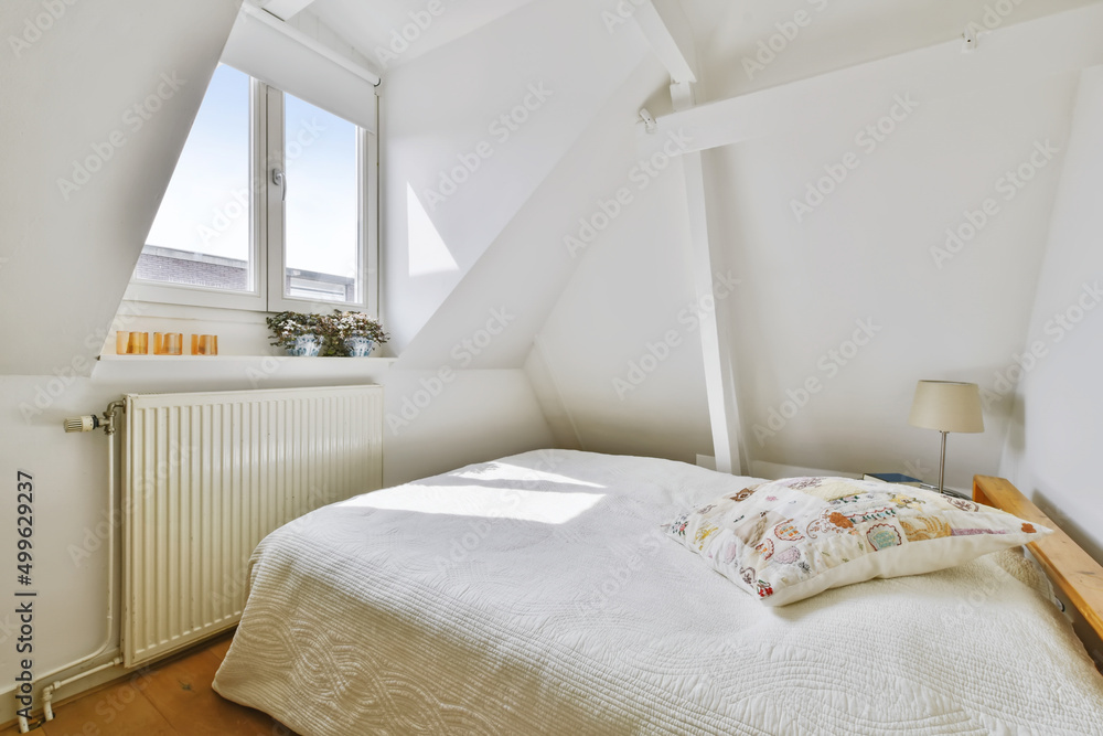 Room with a bed in front of a radiator and a window Stock Photo | Adobe ...