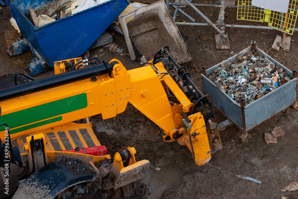 Telehandler on construction site moving heavy steel box full of ...
