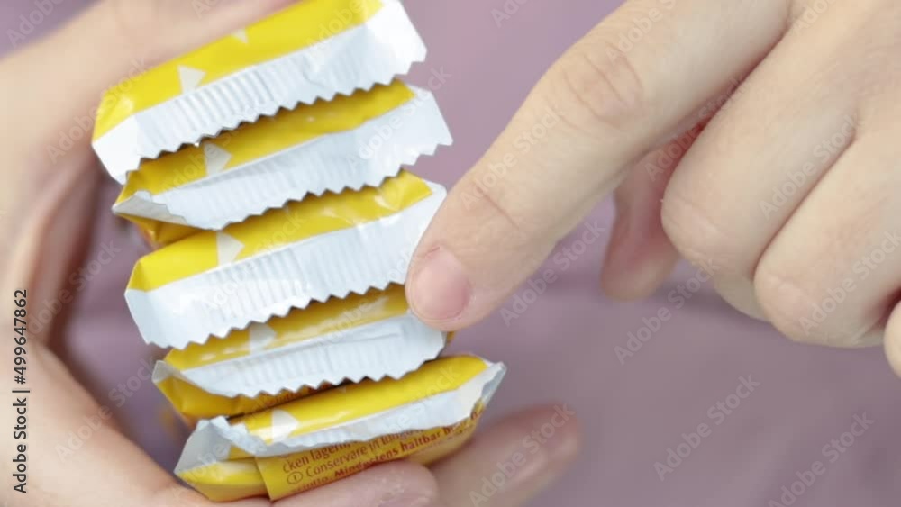 woman's hand is cutting some chocolate bars or cookies wrapped in ...