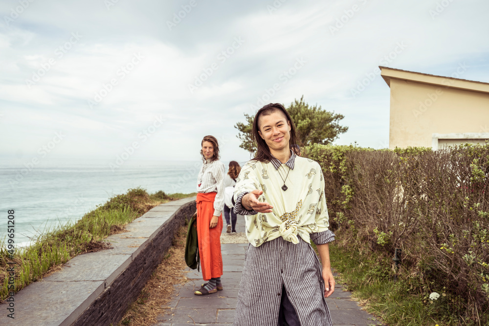 Friendly smiling alternative people offer hand for a walk along ocean ...