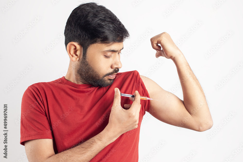 young indian man self injecting hormone steroid syringe into his body ...