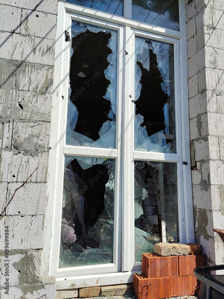 Broken as a result of artillery shelling a window with broken glass ...