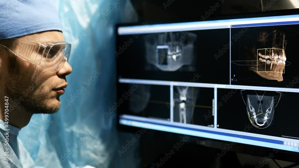 A dentist examines a 3D panoramic image of the jaw on the screen. MRI ...