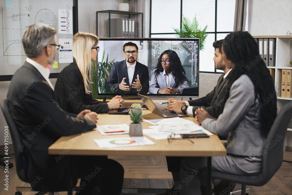 Confident Caucasian business man and African woman tells business ...