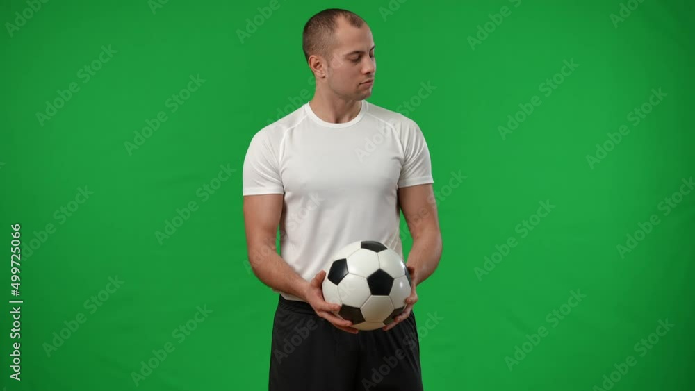 Confident Caucasian young man catching football ball in slow motion on ...