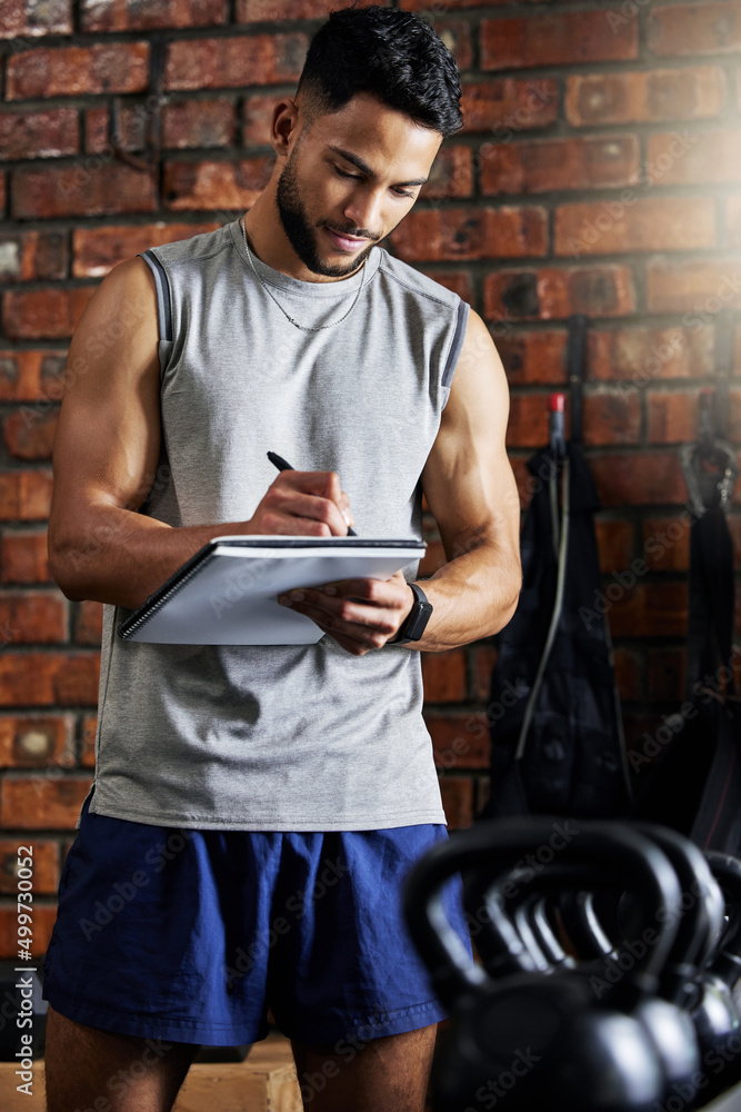 Fully equipped gym, happy clients. Shot of a young man doing inventory ...