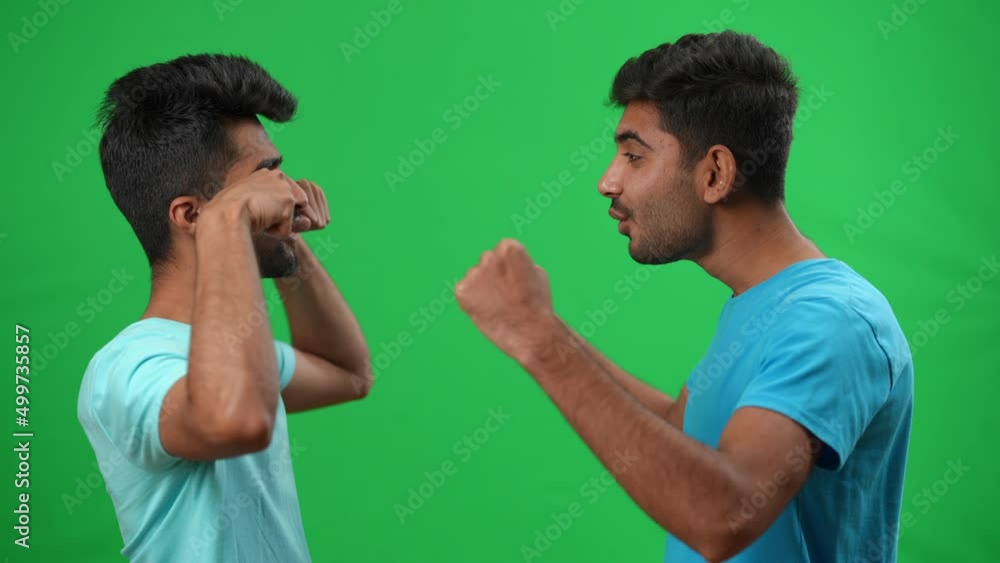 Side view two positive Middle Eastern men gesturing high-five on green ...