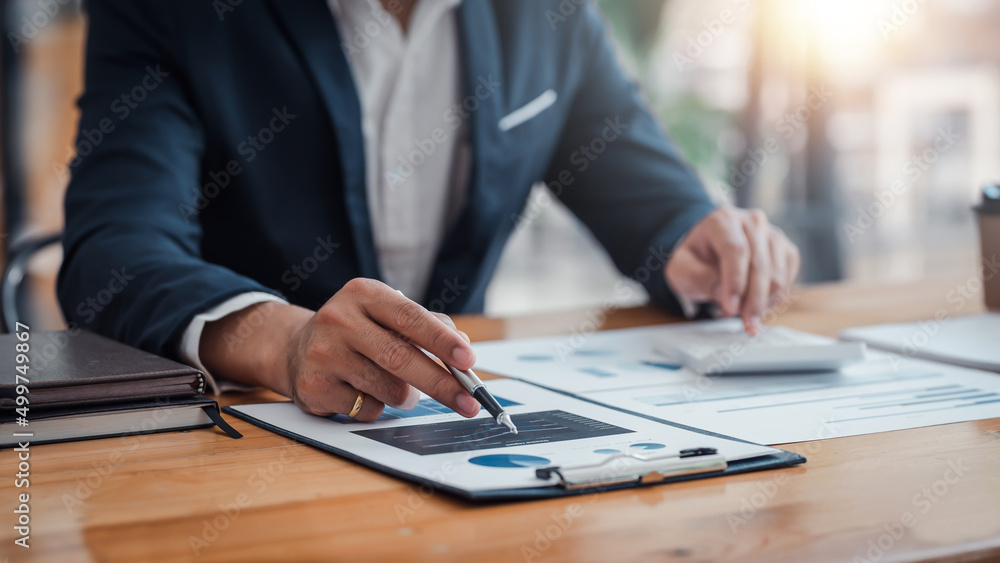 Business man using a calculator to check income and budget in a company ...