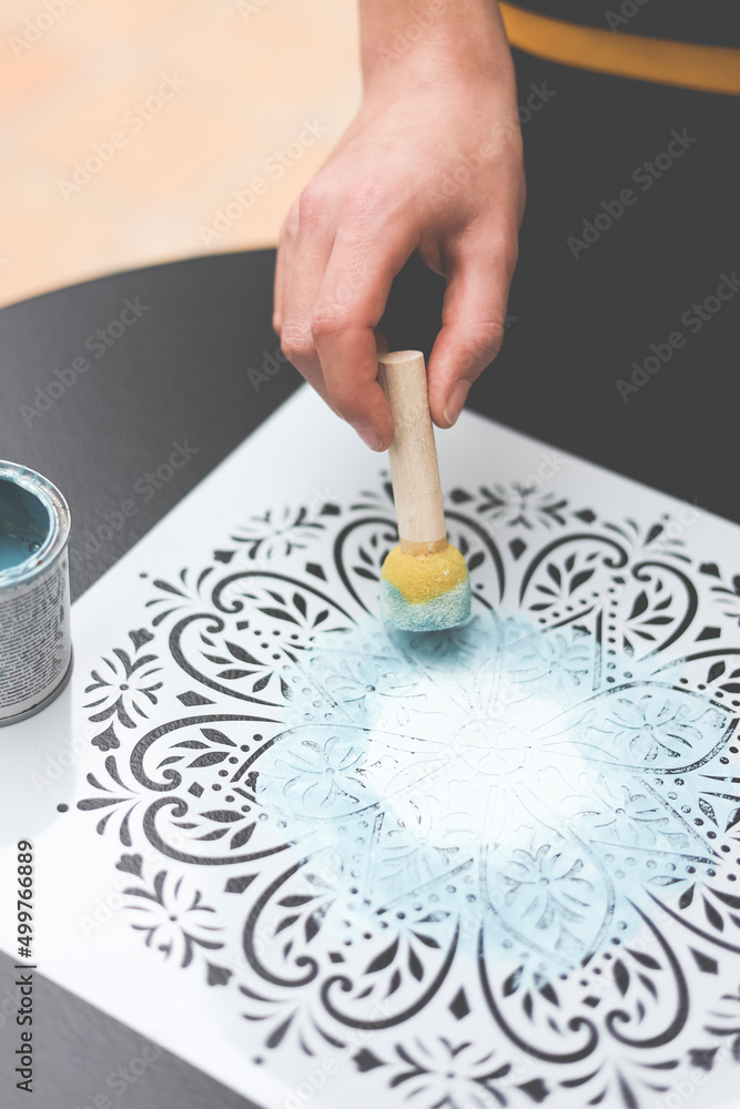Person using a dabber with acrylic paint on a mandala stencil Stock ...