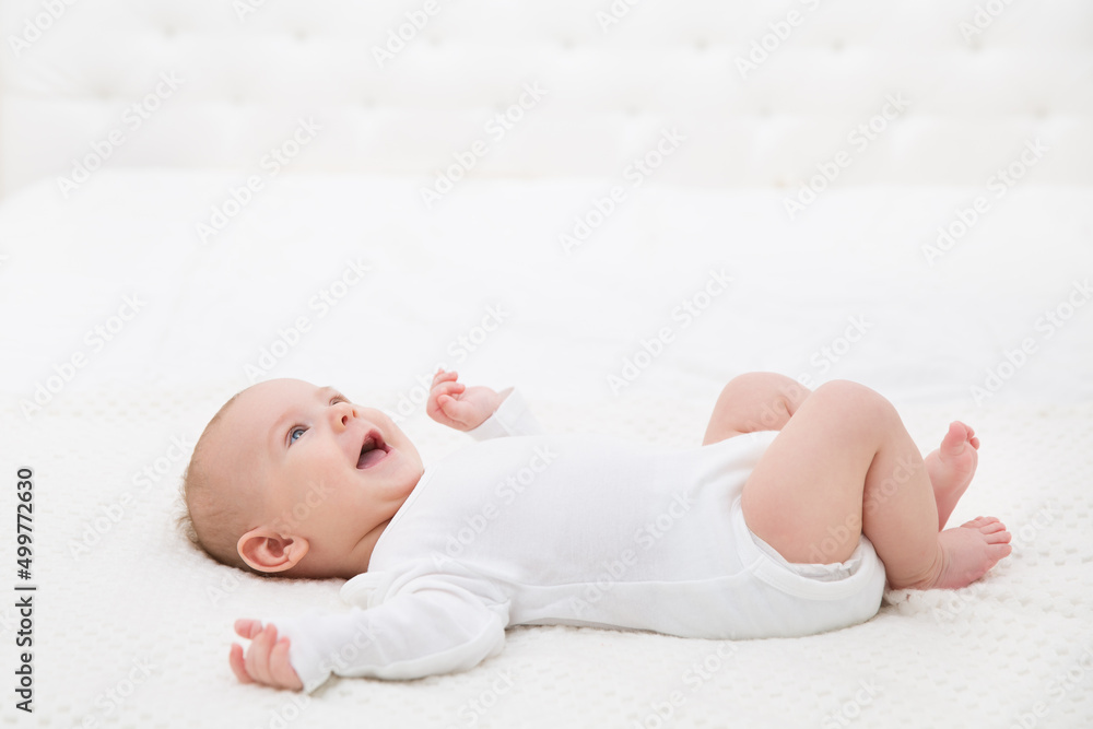 Happy Smiling Baby in White Cotton Onesies in Bed lying on Back Side ...