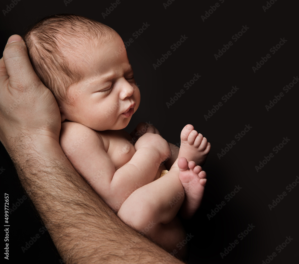 Newborn Baby lying on Father Hand over Black Background. Child sleeping ...