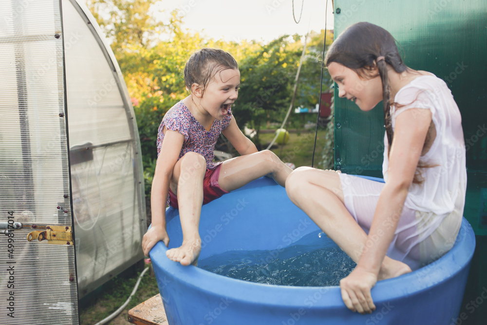 Hot summer and happy childhood. Children splash in a barrel Cheerful ...