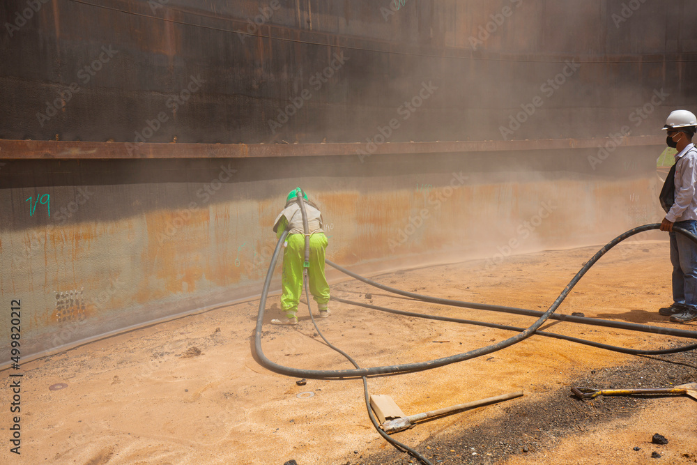 Female worker surface corrosion plate preparation by sand blasting of ...