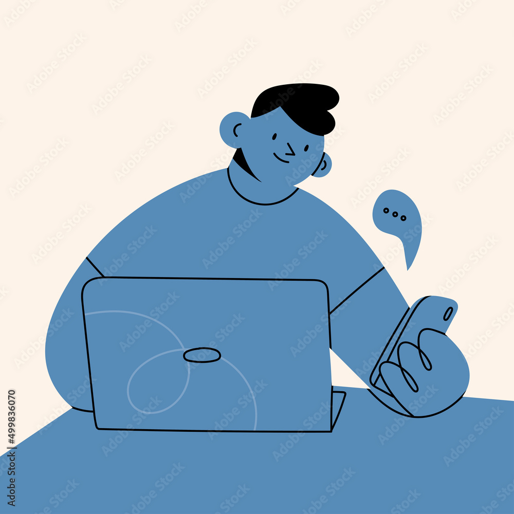 Young person sitting at table, using laptop, looking at smartphone ...