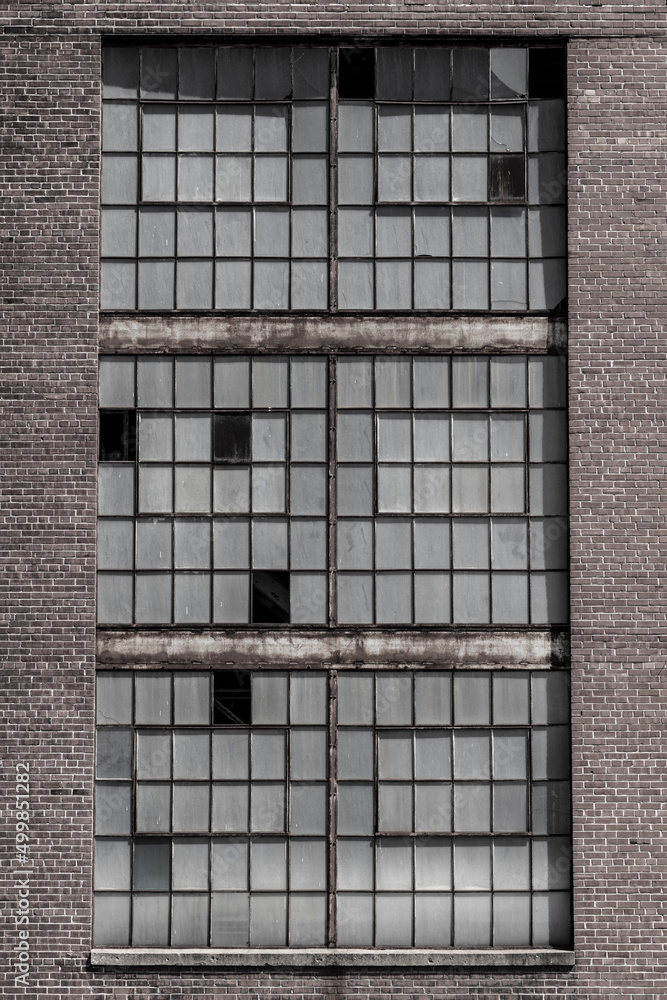 Broken windows and worn exterior of an abandoned coal power plant. Coal ...