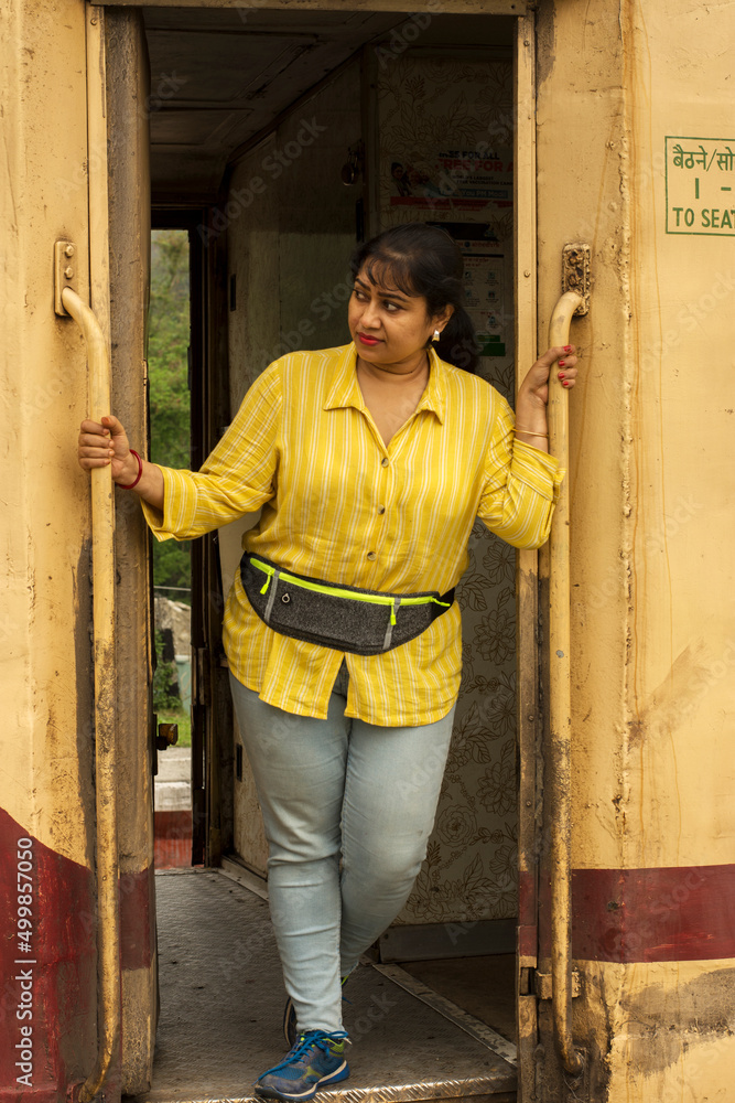 Foto de An young female solo traveler just getting down from the train ...