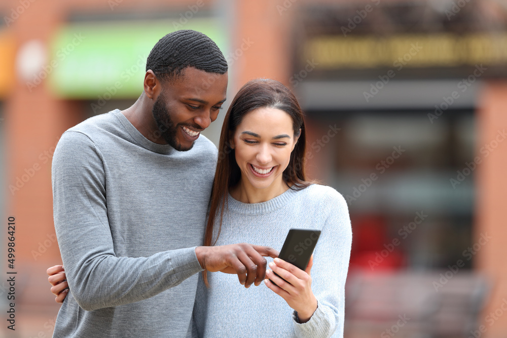 Happy interracial couple checking cell phone outdoors Stock Photo ...
