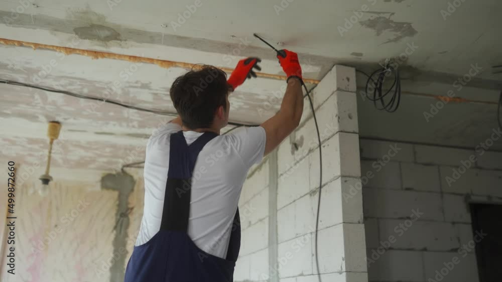 Electrician laying wiring cable, mounting electricity lines in the ...