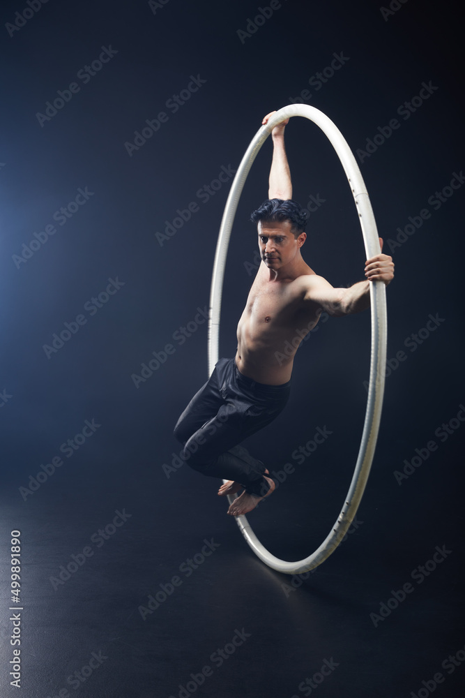 Circus performer artist with muscles body in a Cyr Wheel (Roy Cyr ...