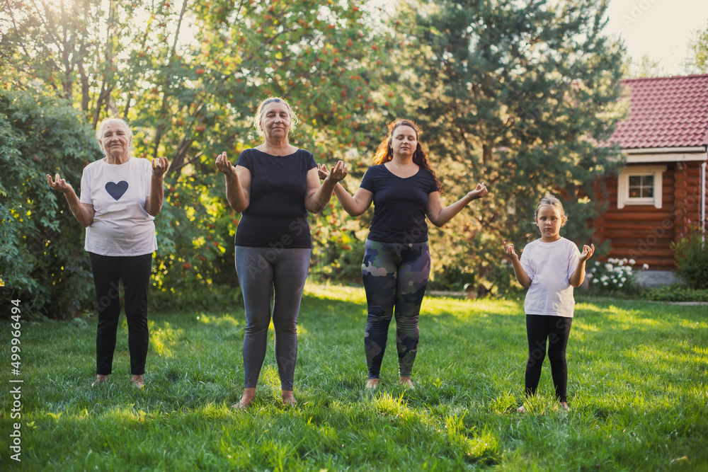 Shining females four generations of family doing yoga meditating with ...