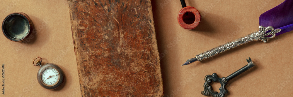 Mysterious vintage objects panorama. Old notebook, a retro key, a quill ...
