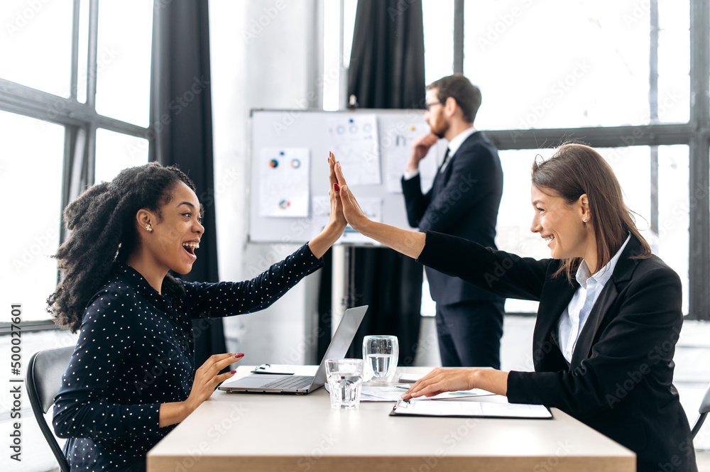 Good deal. Great job. Two successful multi-ethnic female colleagues ...