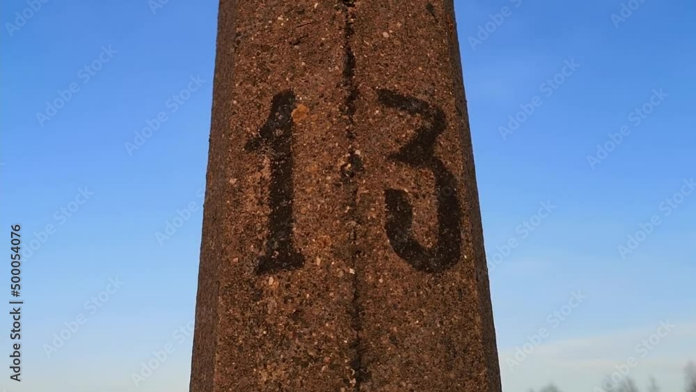 The number 13 is drawn in black paint on a pole close-up against the ...