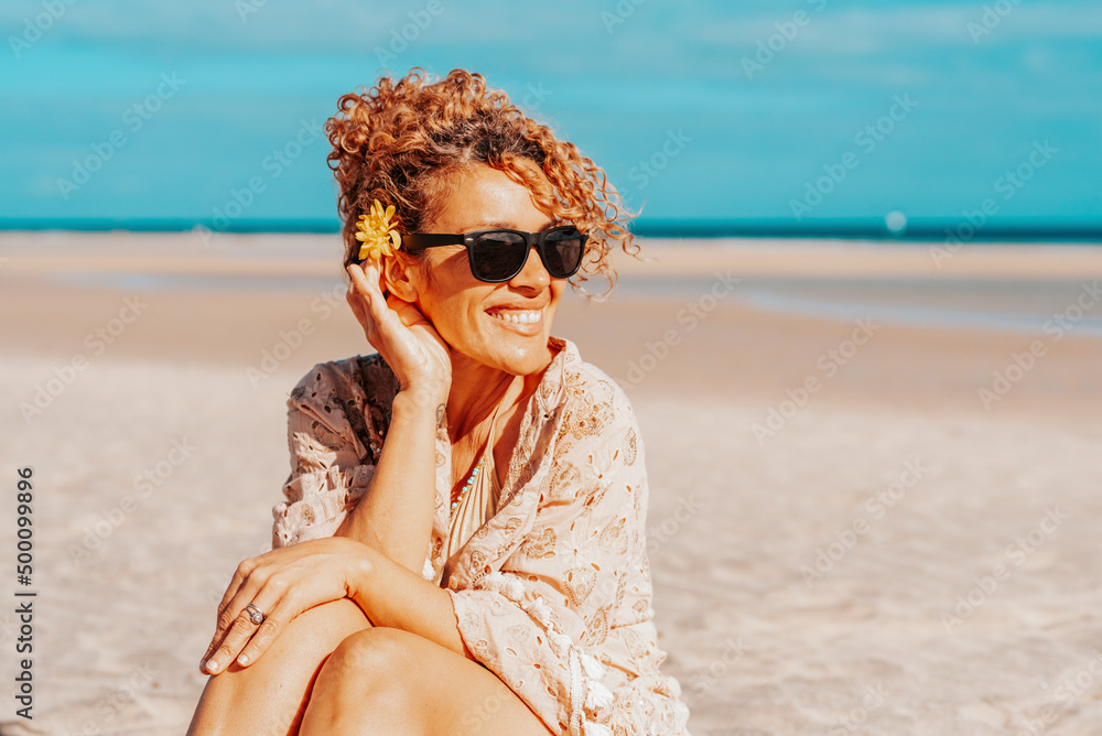 Portrait of happy tourist sitting and smiling at the beach with blue ...