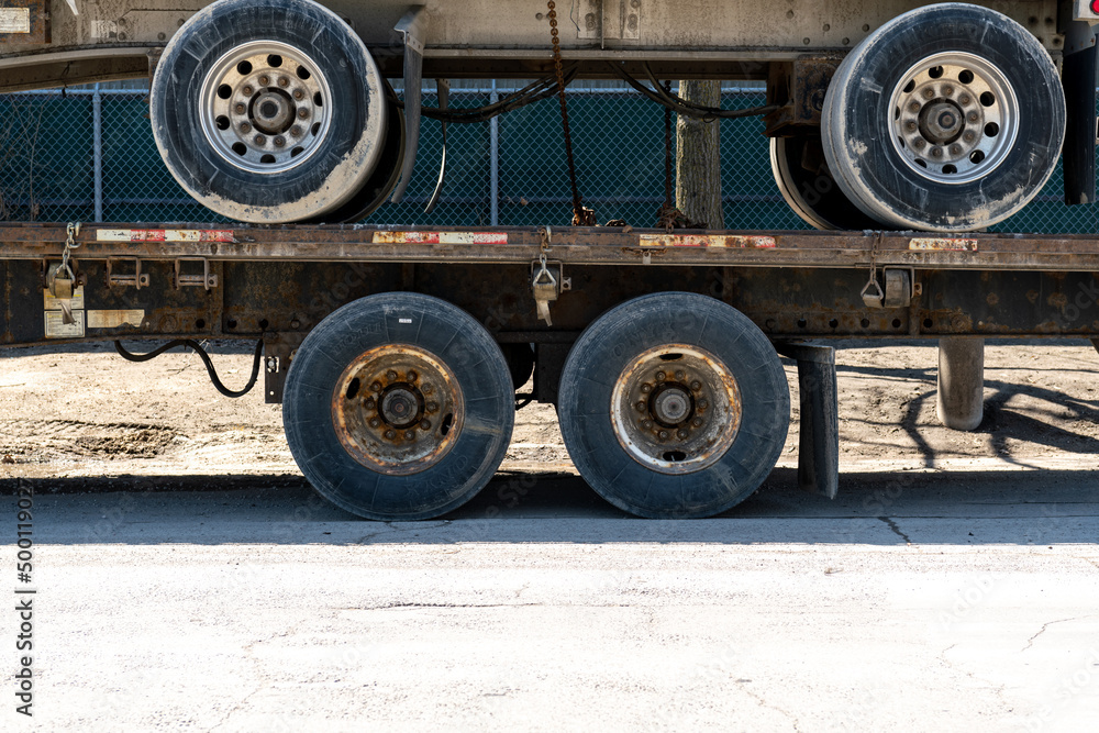 Rear wheel systems on two flatbed trailers, one stacked upon the other ...