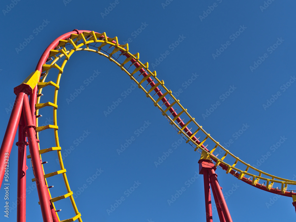 Close-up view of the red and yellow colored rails of a roller coaster ...