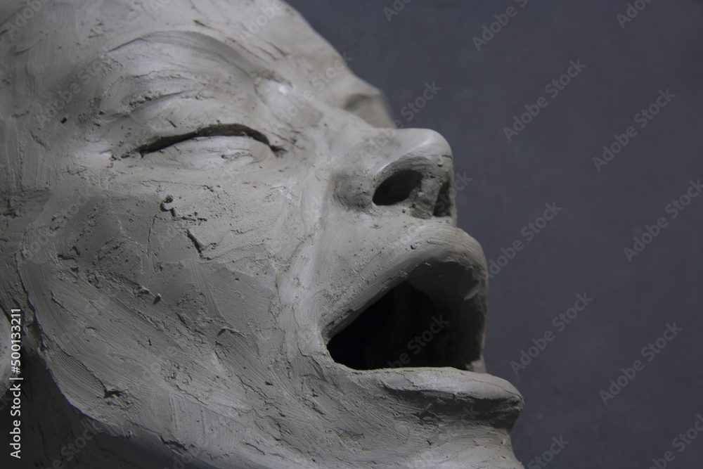 Portrait of the girl with open mouth. Expressive sculpture, female face ...