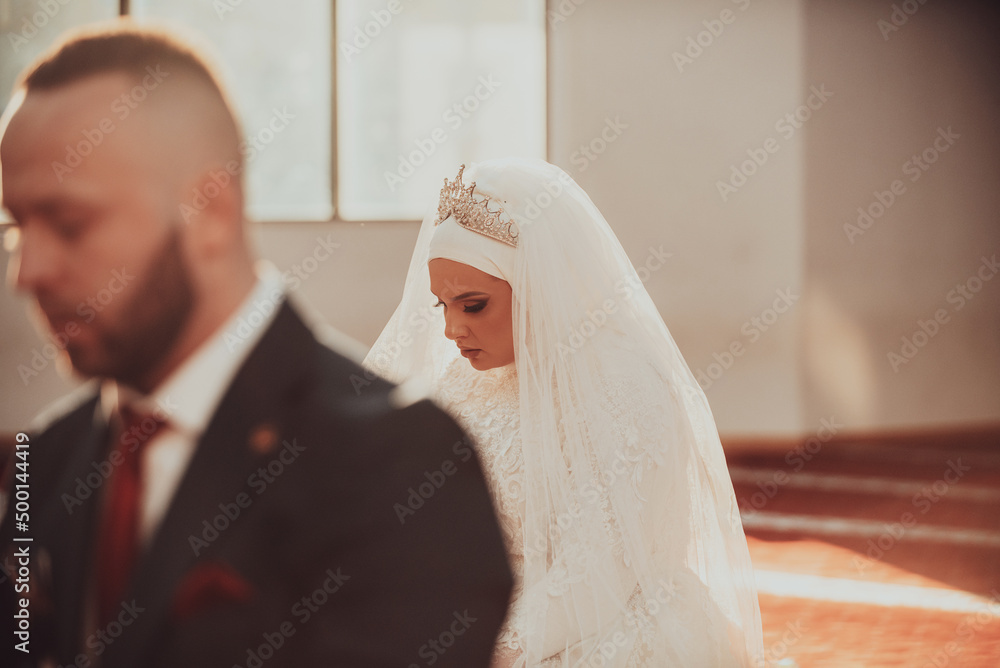 Muslim bride and groom praying at the mosque during a wedding ceremony ...