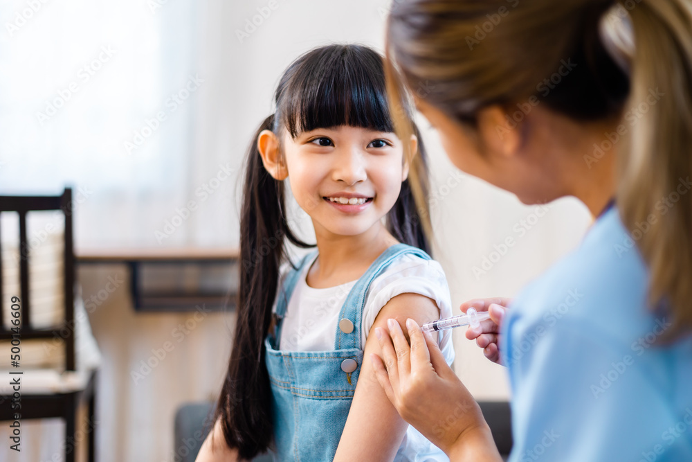 Childhood vaccination. Asian young woman doctor vaccinating little girl ...