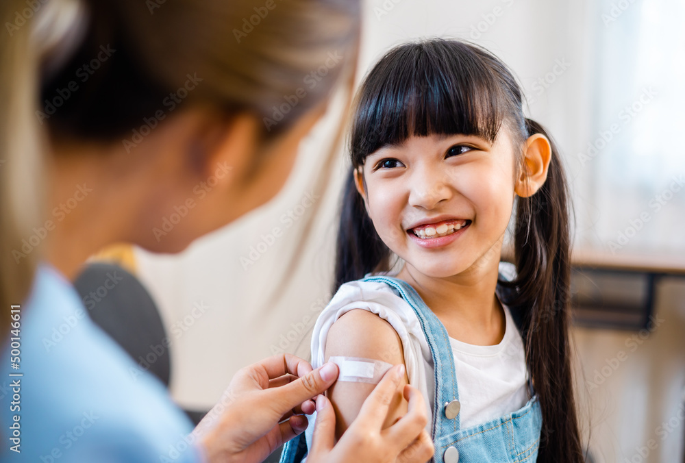 Childhood vaccination. Asian young woman doctor vaccinating little girl ...