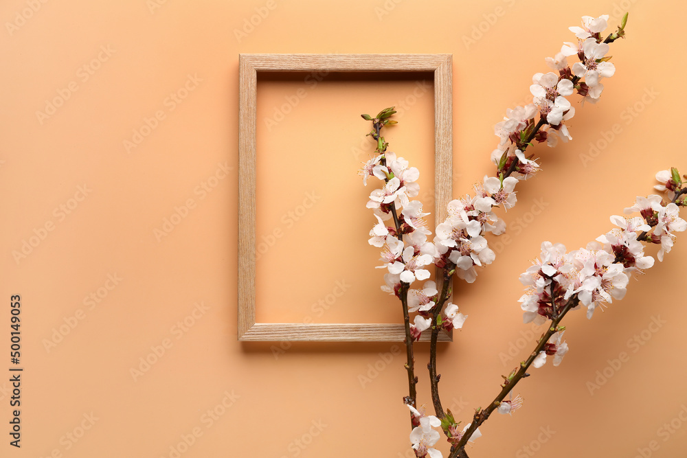 Beautiful blooming spring branches and blank frame on beige background ...