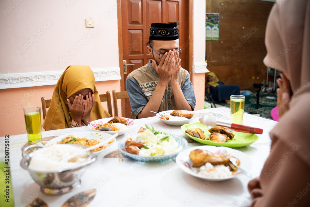 muslim family pray and thanking god for the food while breaking the ...