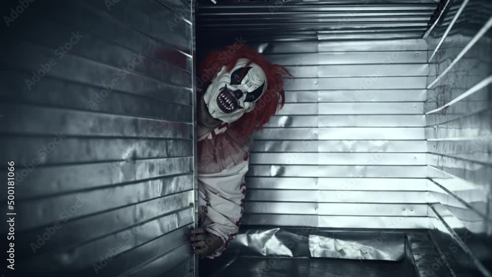 Scary clown attacks in a closed ventilation duct. Scary psychopath in a ...